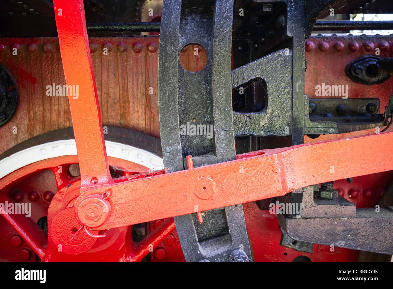 A red and black train engine with a red and black chain. The chain is ...