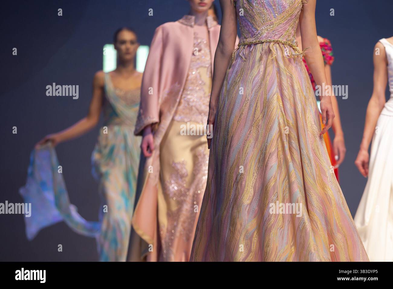 Female models walk the runway in beautiful colorful dresses during a ...