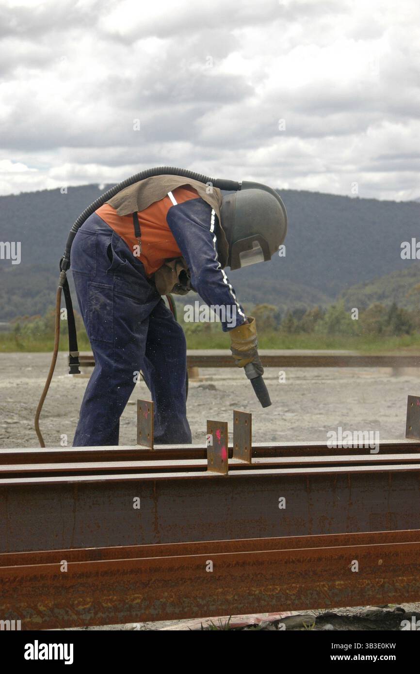 Tradesman sandblasting beams for building project, West Coast, New ...