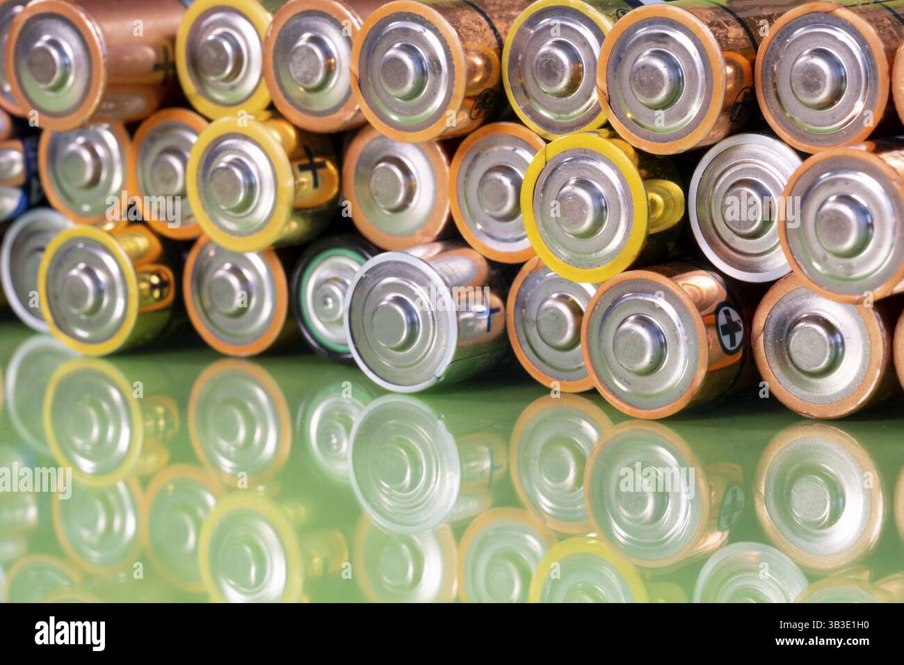 Multiple used AA alkaline batteries are seen arranged in a pile on a ...