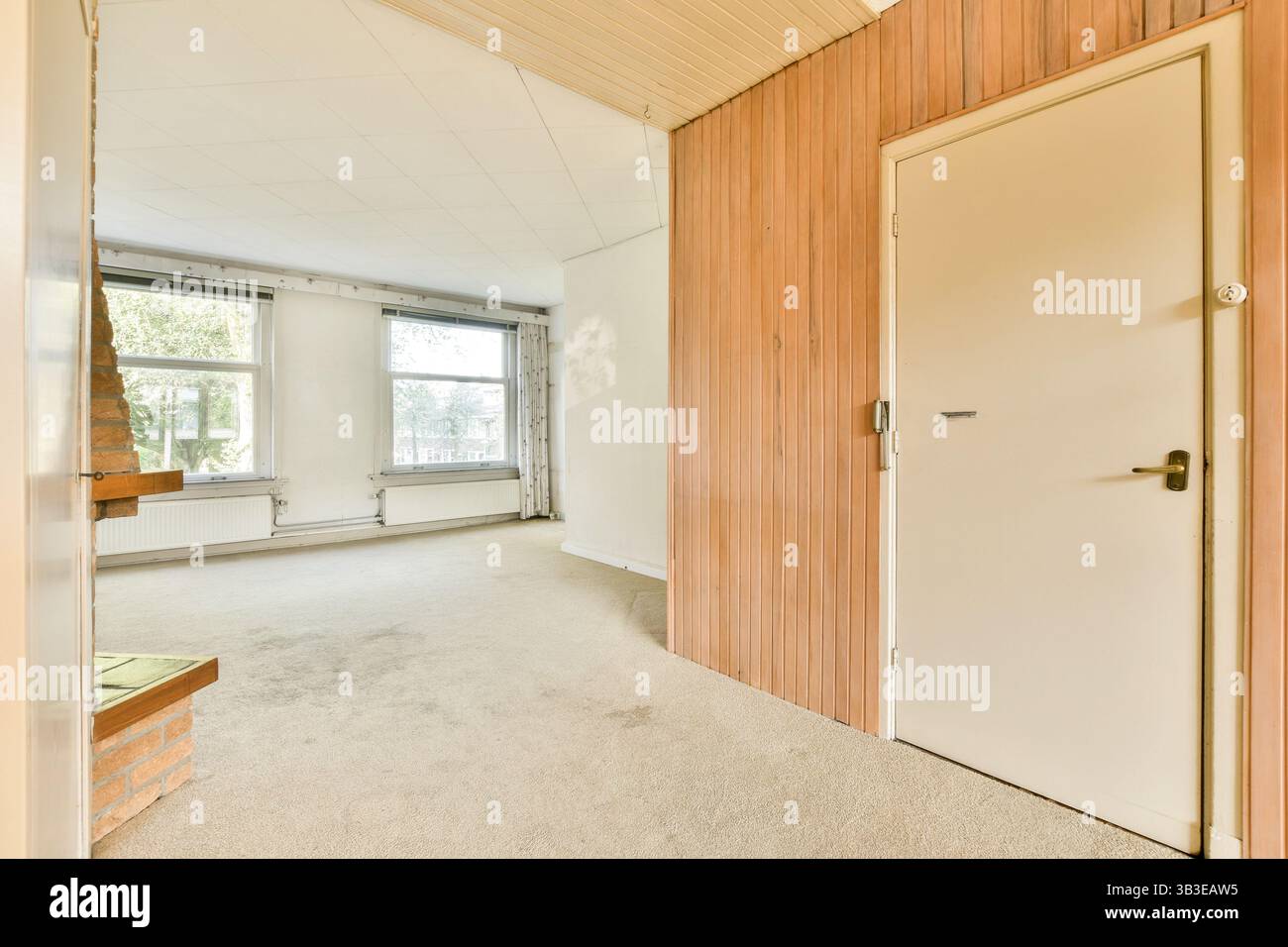 A spacious and well-lit interior hallway featuring wooden paneling ...