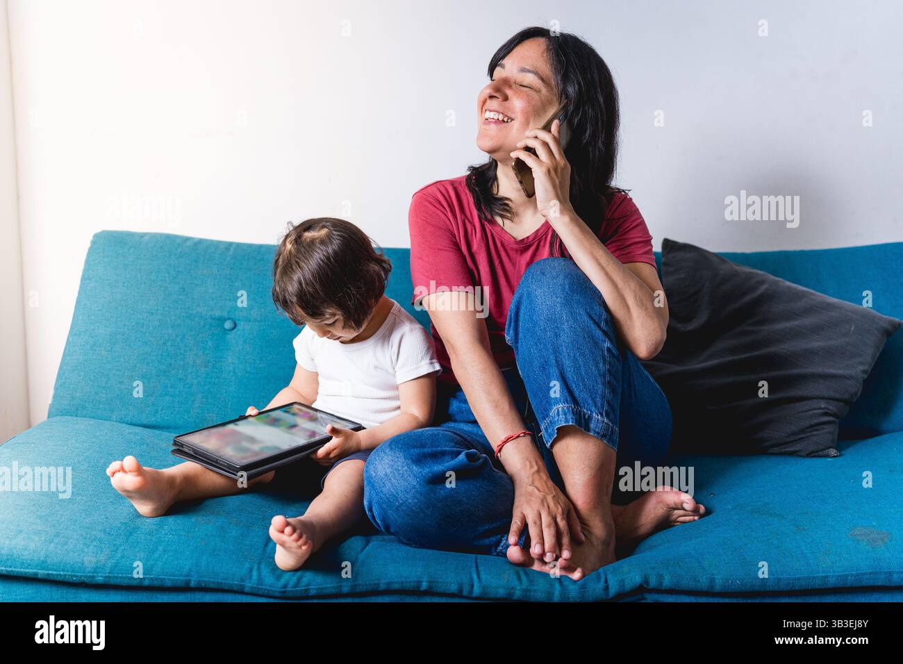 Baby toddler and mother looking at tablet and mobile phone, checking ...