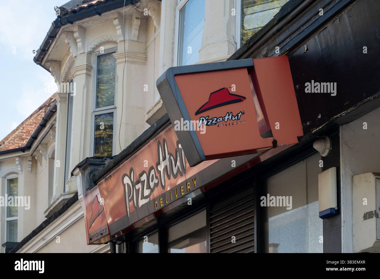 Signage at the front of a Pizza Hut delivery store in England. April ...