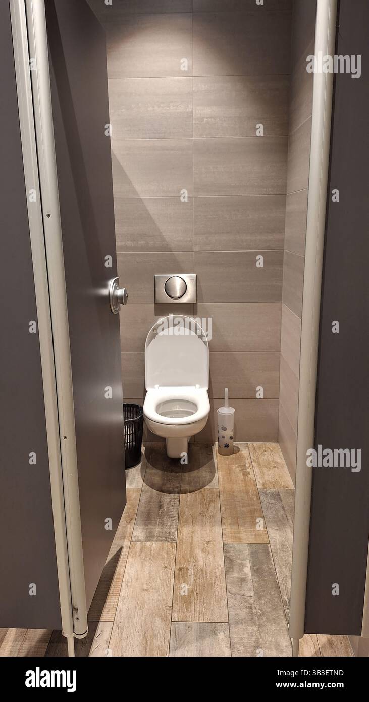 Clean public restroom stall with modern toilet and wooden floor Stock ...