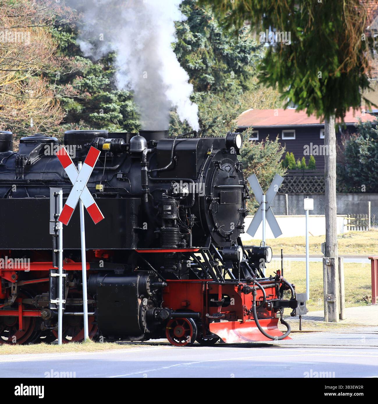 Historic steam locomotive crossing a rural railway intersection in ...