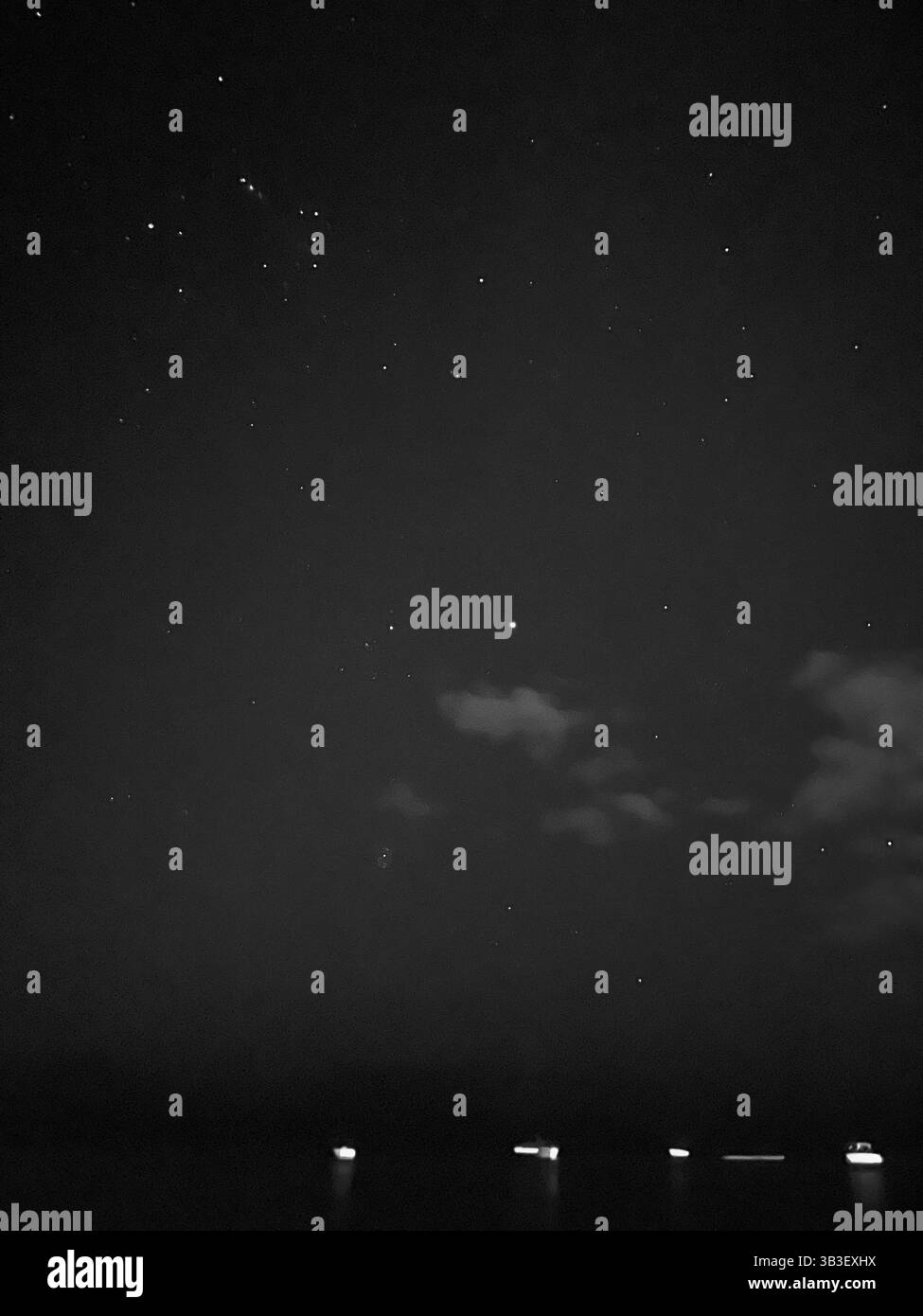 Black and white photo at night starry sky on the horizon in the ocean ...