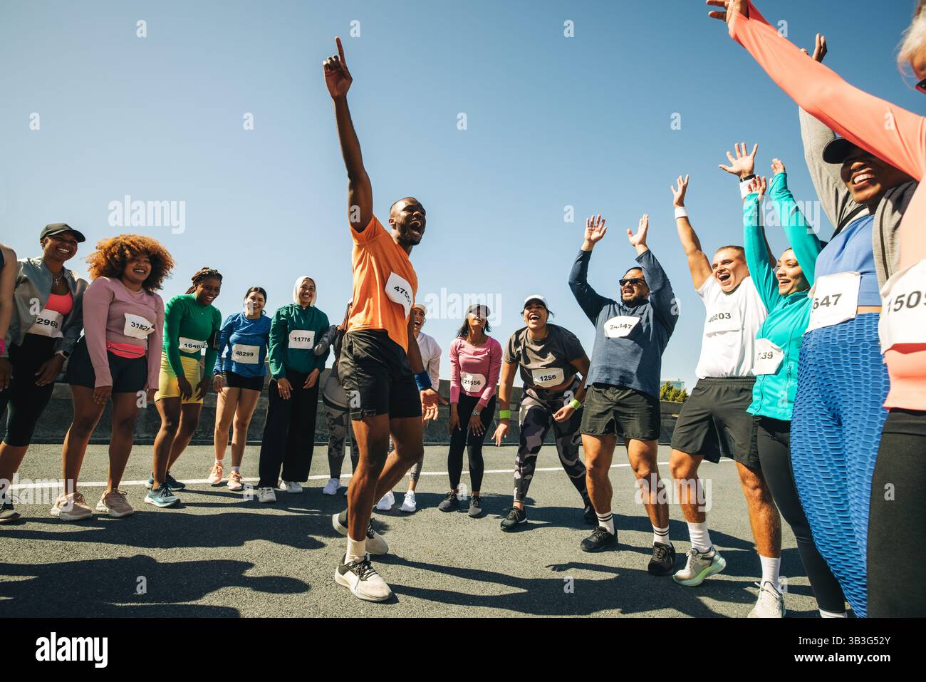 A diverse team of enthusiastic runners shares an energetic moment with ...