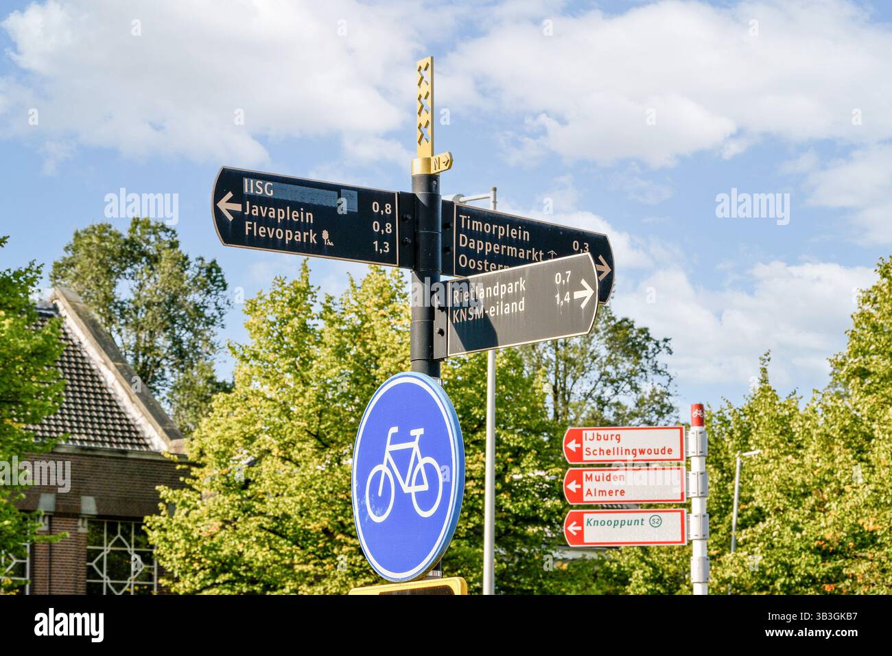 Multiple directional signs indicate various routes and locations ...