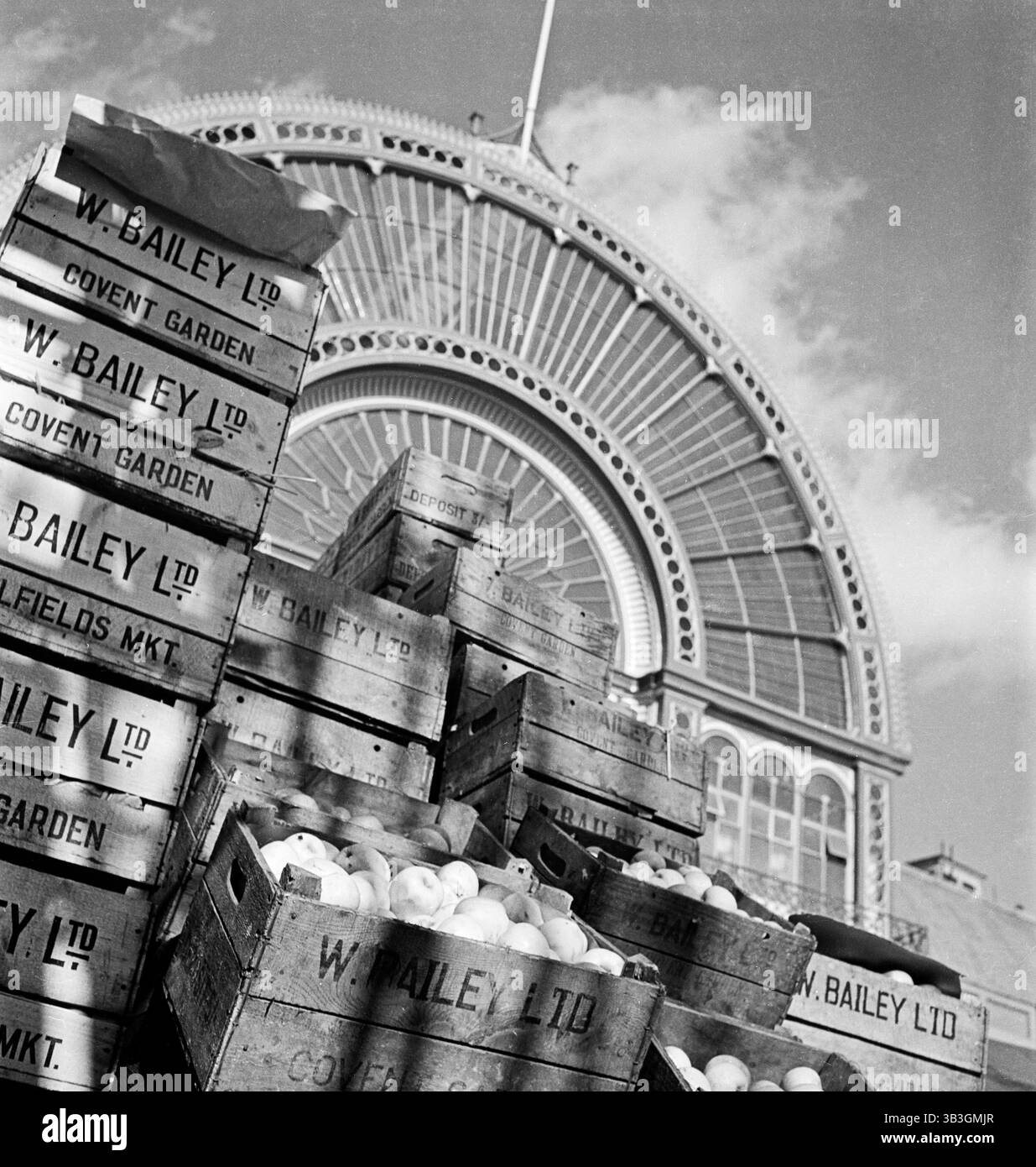 Looking up at the arched iron and glass facade of Covent Garden market ...