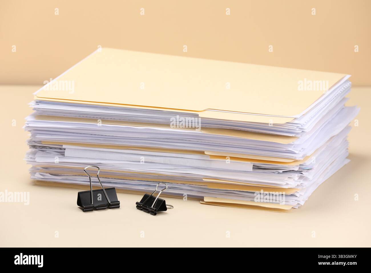 File folders with papers and binder clips on pale yellow background ...