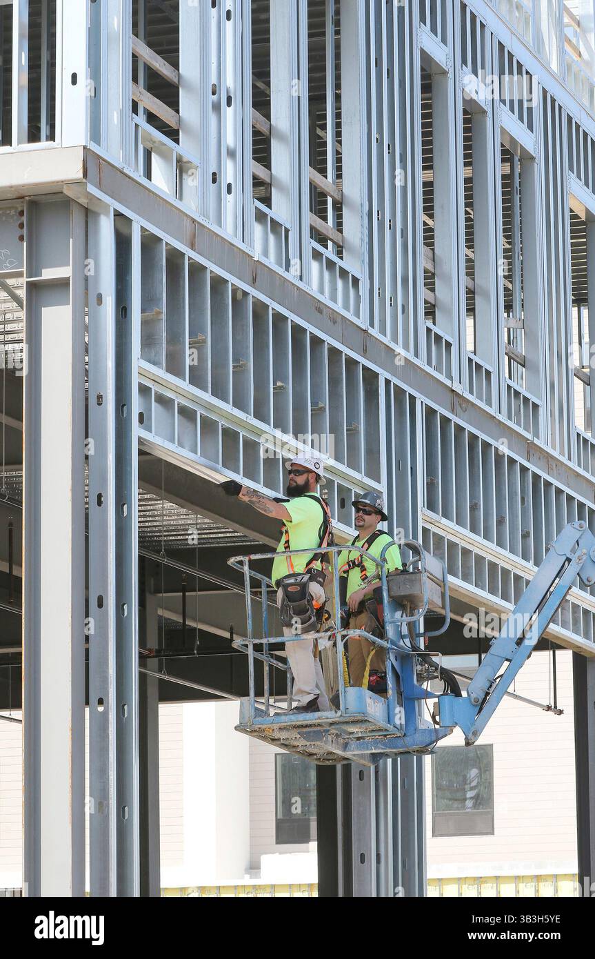 Derek Plemens left, measures the length for a board as he works with ...