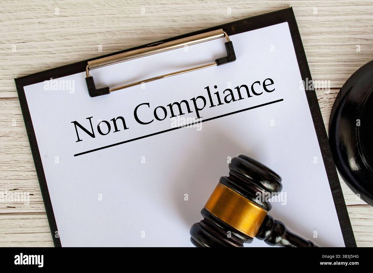 Top view of Non Compliance text on clipboard with gavel on top ...