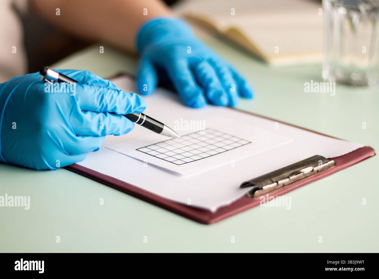 Doctor or physician in blue gloves writing diagnosis and think trough ...