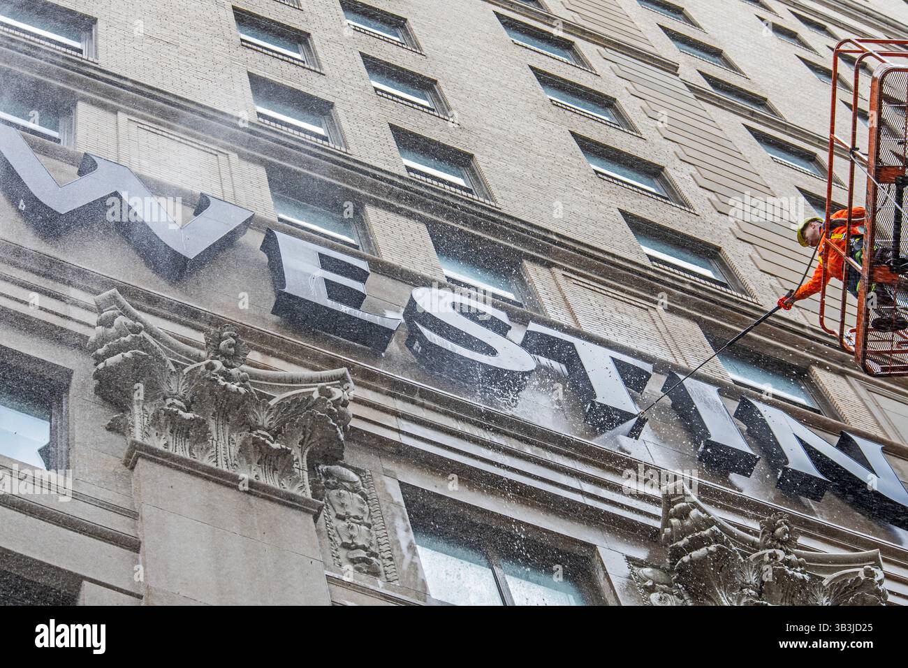 Detroit, Michigan - A worker uses a high-pressure water spray to clean ...