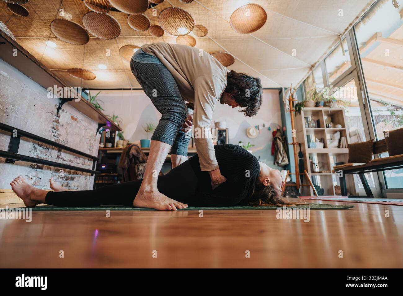 Yoga instructor guiding student through hi-res stock photography and ...
