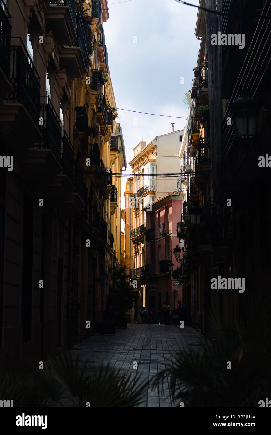 Shaded Street Leading to Sunlit Yellow and Pink Buildings in Valencia ...