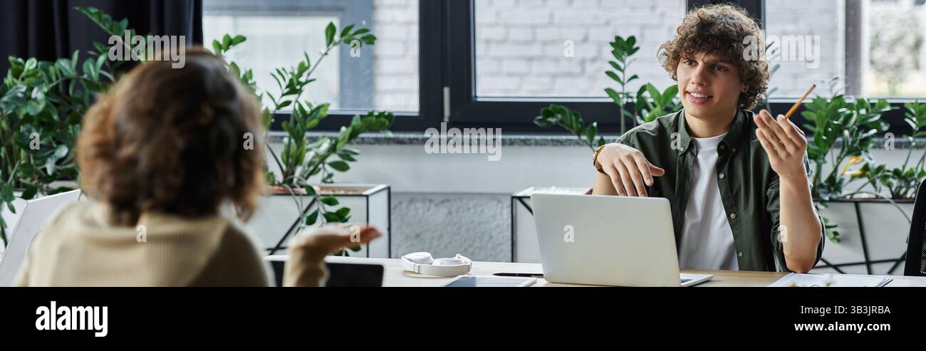 Two colleagues engage in a dynamic discussion while surrounded by ...