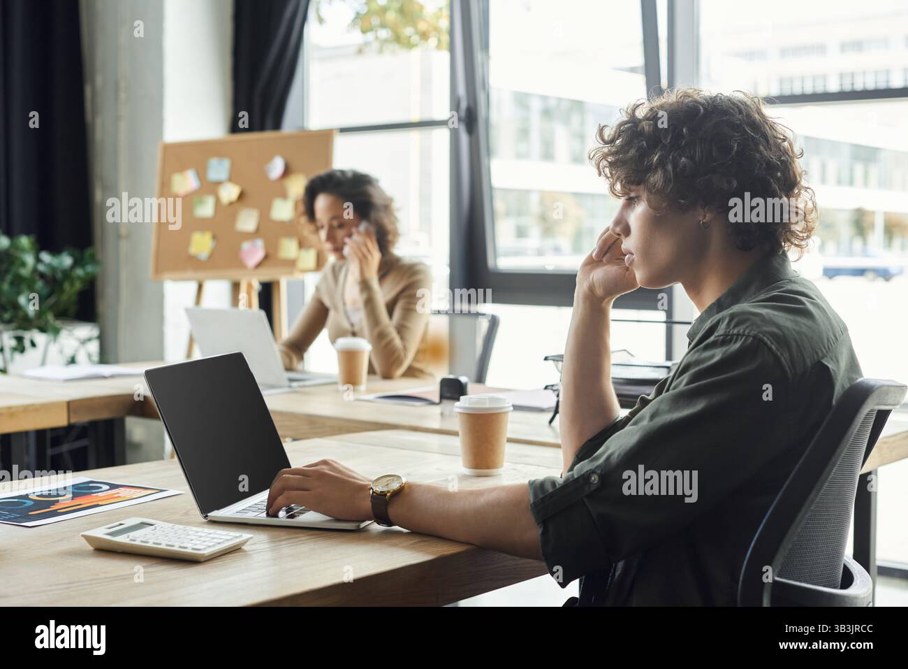 Two office workers focus on their tasks, demonstrating dedication and ...