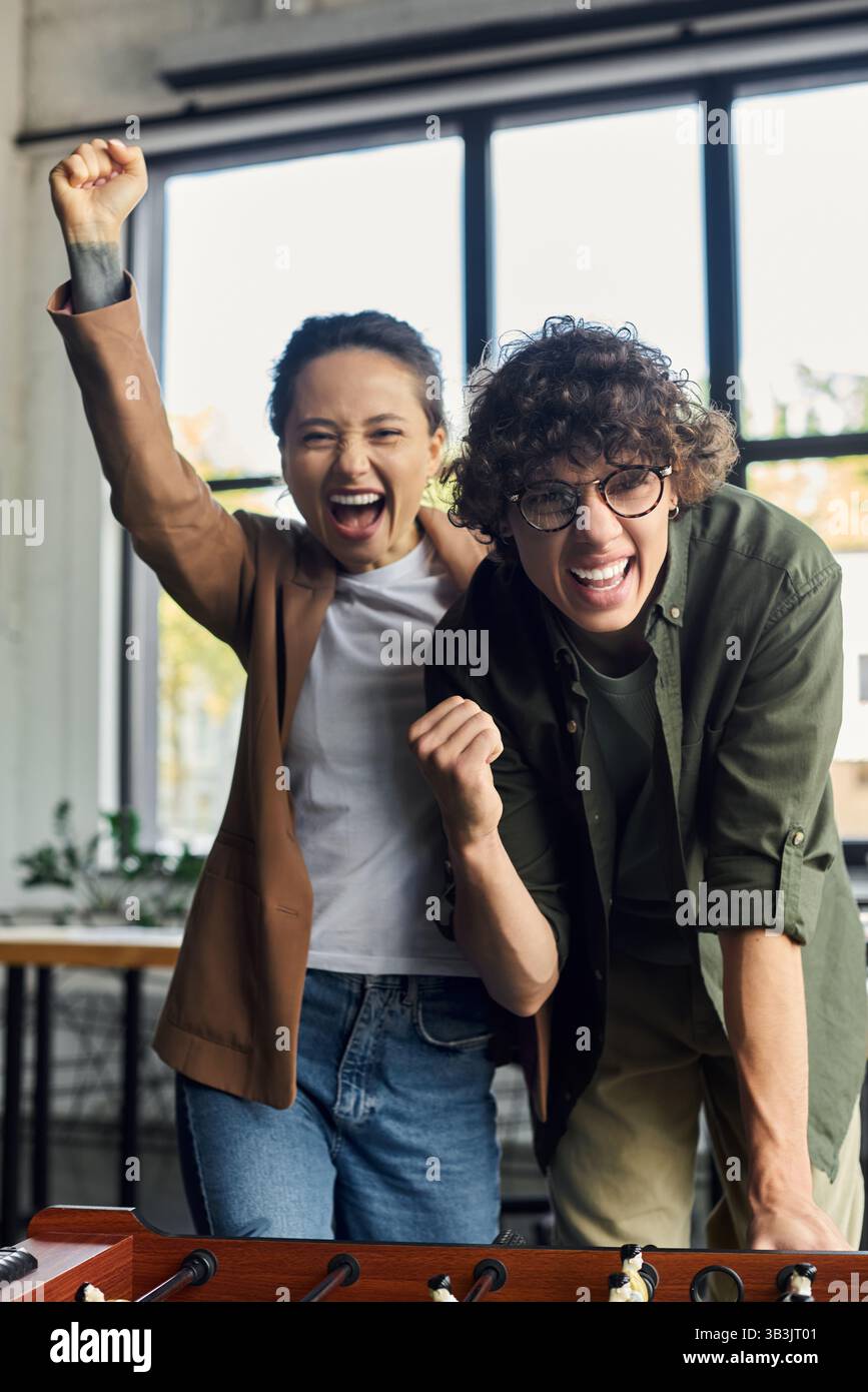 Two enthusiastic coworkers share a joyful moment in a bright office ...