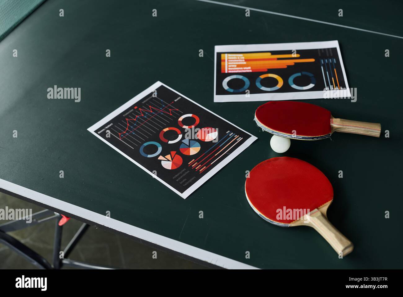 Two red ping pong paddles and a ball are resting beside performance ...