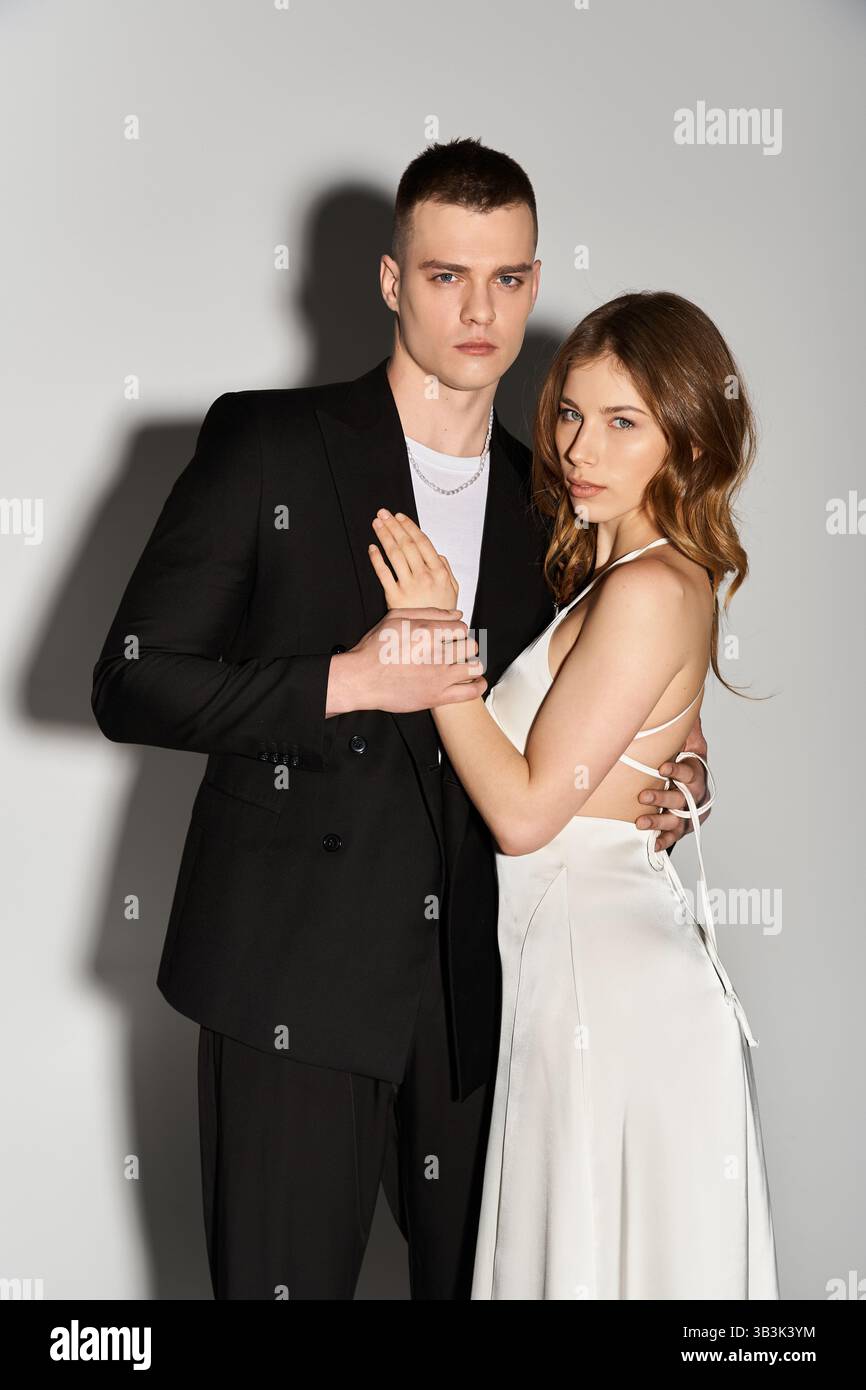 A young couple stands close, radiating elegance and connection in a ...