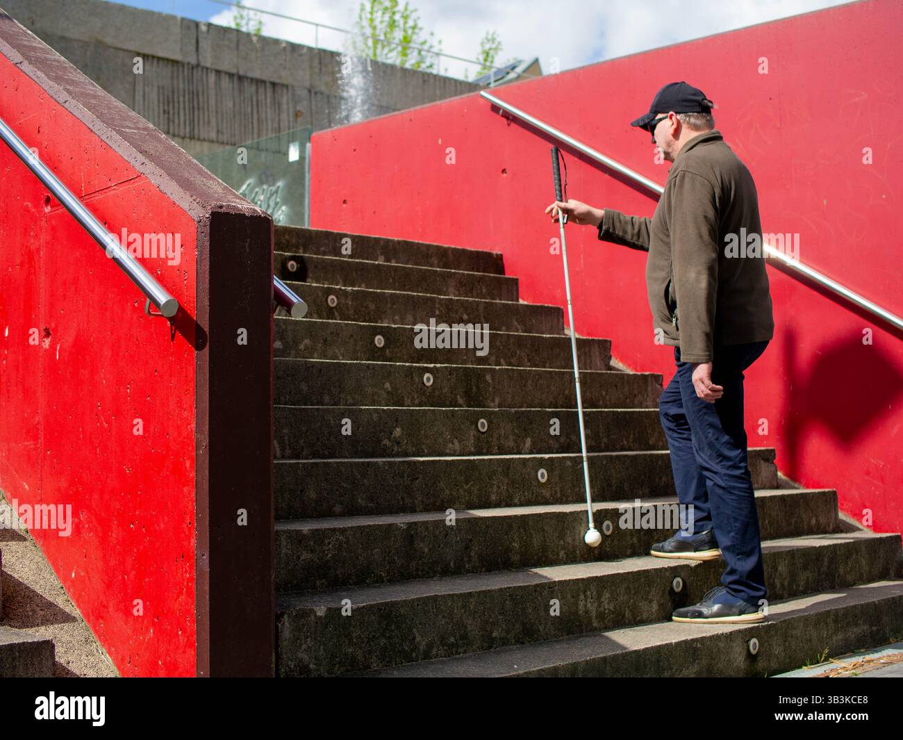 sightless man using his guide cane to go upstairs in a park Stock Photo ...