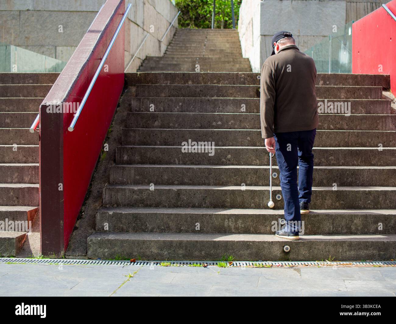 sightless man using his guide cane to go upstairs in a park Stock Photo ...