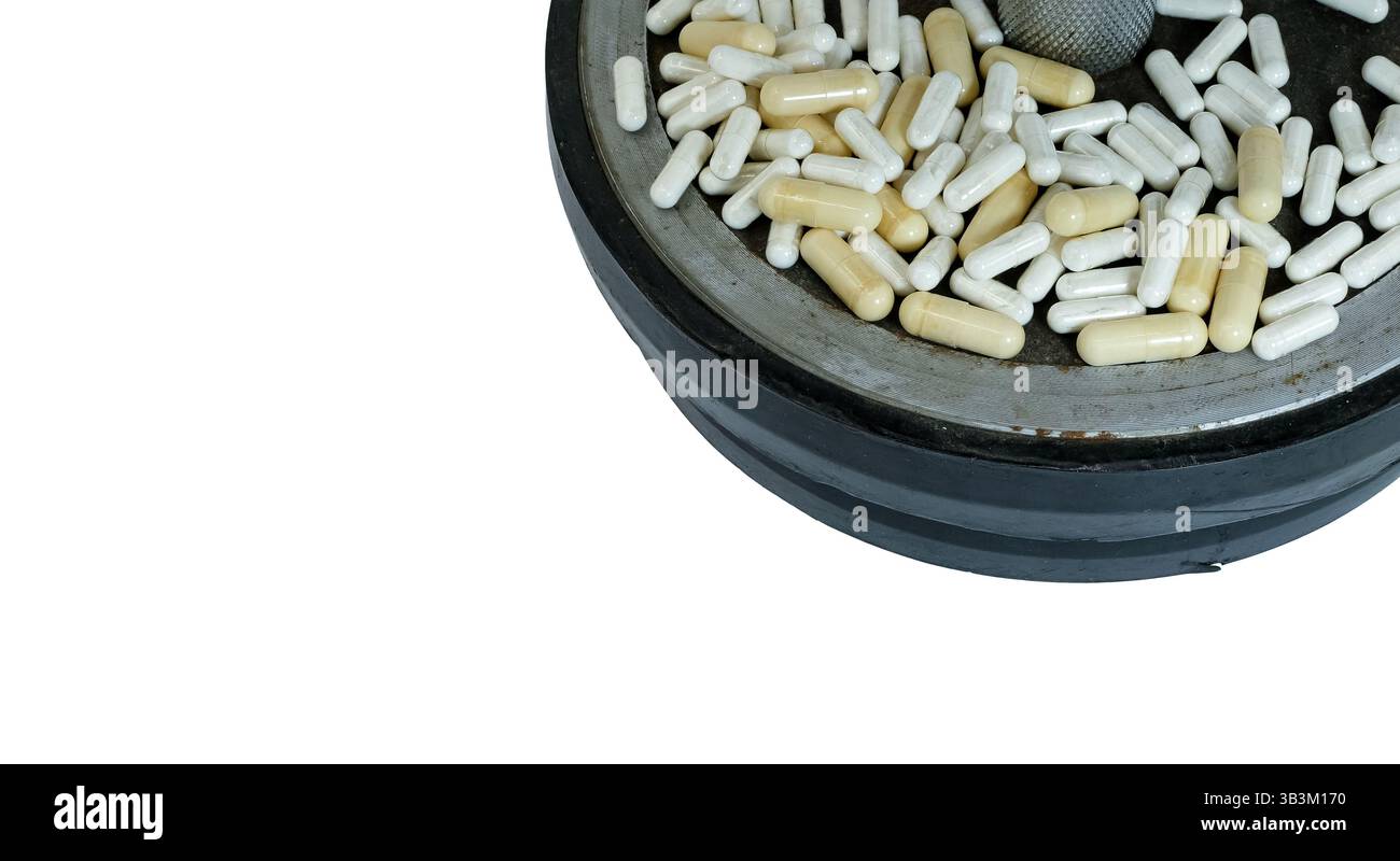 Pile of dietary supplement capsules on the metal dumbbell surface ...
