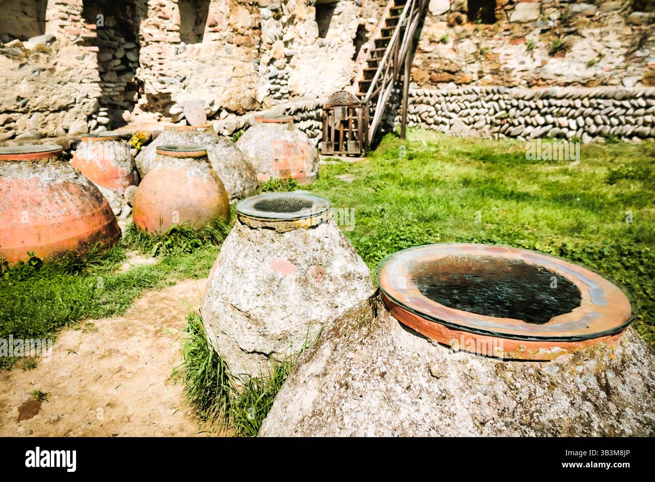 Traditional Georgian qvevri clay vessels covered with glass lids in a ...