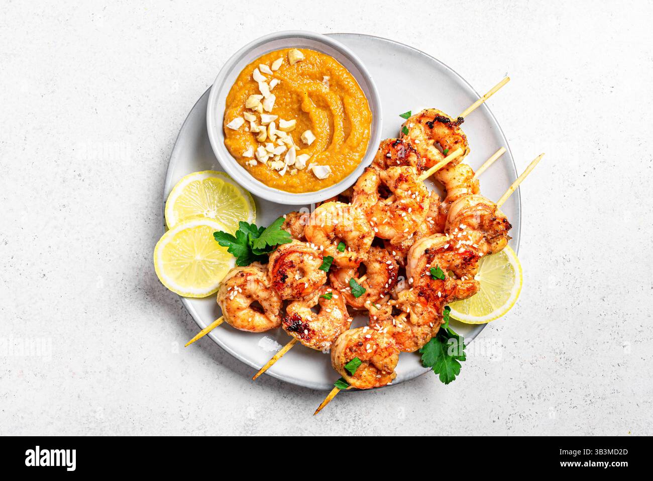 Grilled shimp prawn satay with spicy peanut sauce on white concrete ...