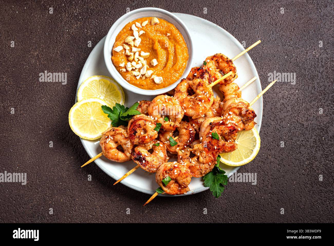 Grilled shimp prawn satay with spicy peanut sauce on dark background ...