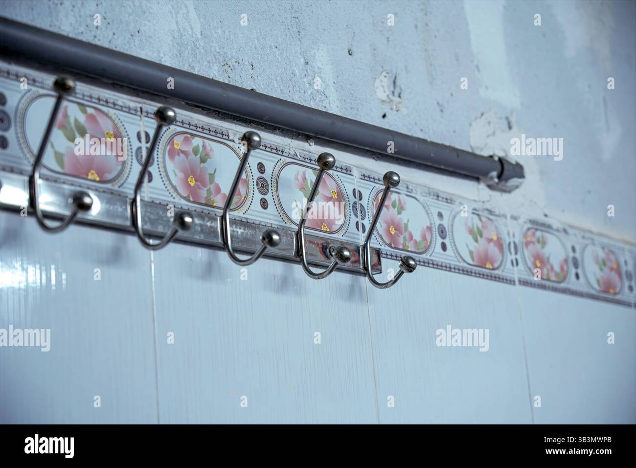 Wall-mounted hooks with floral tiles in a vintage setting Stock Photo - Alamy