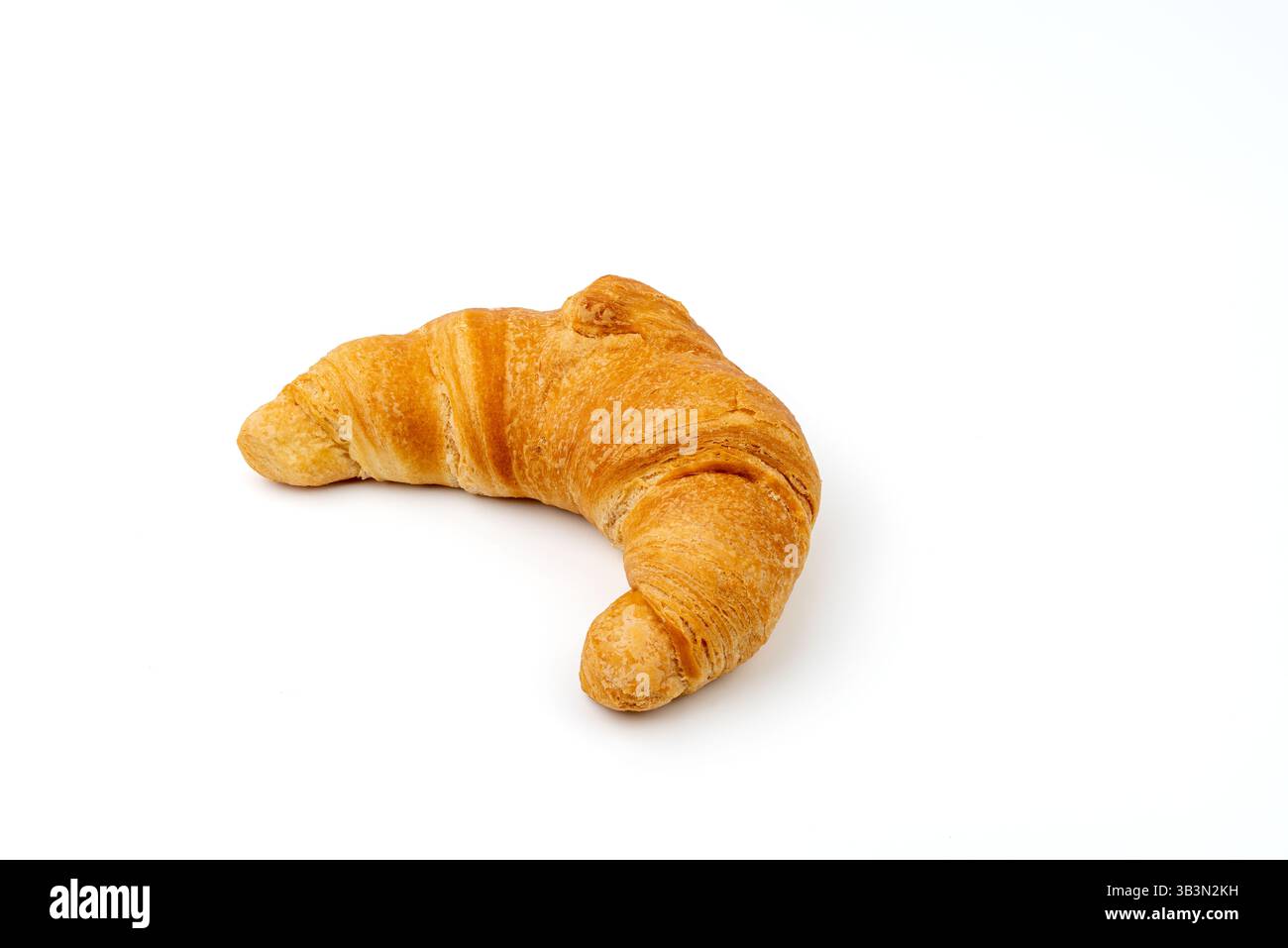 A croissant is on a white background. It is brown and has a curved ...
