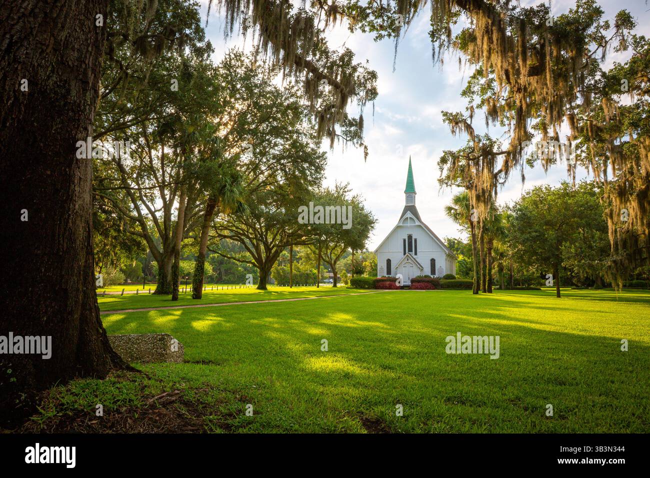 White chapel with lawn framed by trees and Spanish moss Stock Photo - Alamy