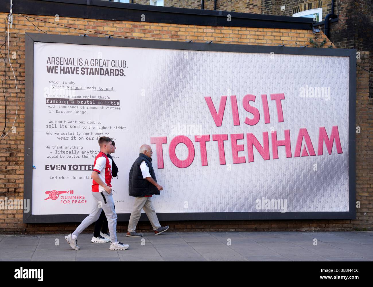 Arsenal fans walk past a Gunners For Peace billboard ahead of the UEFA ...