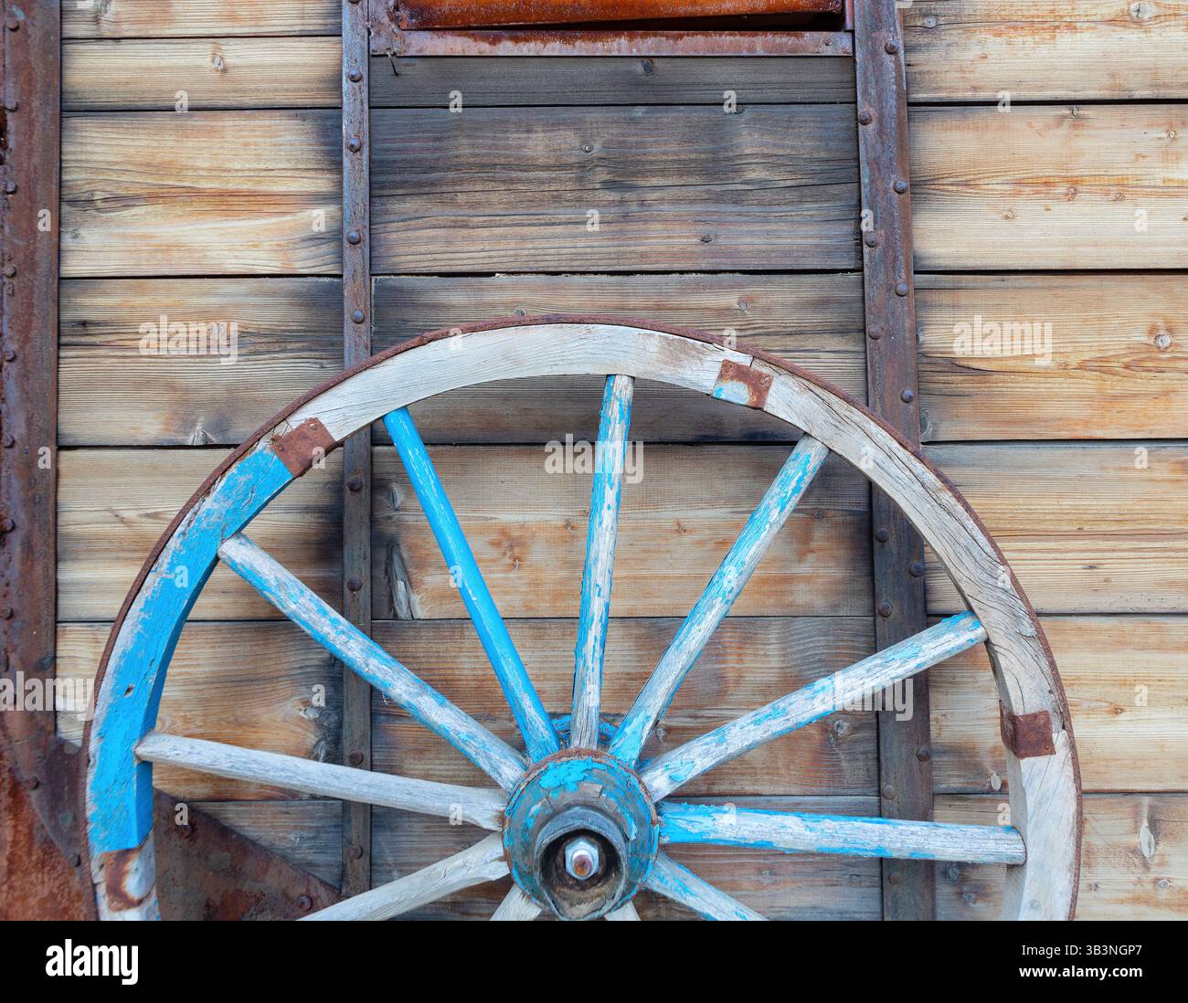 A old horse cart wheel in front of wooden background. Vintage wagon ...