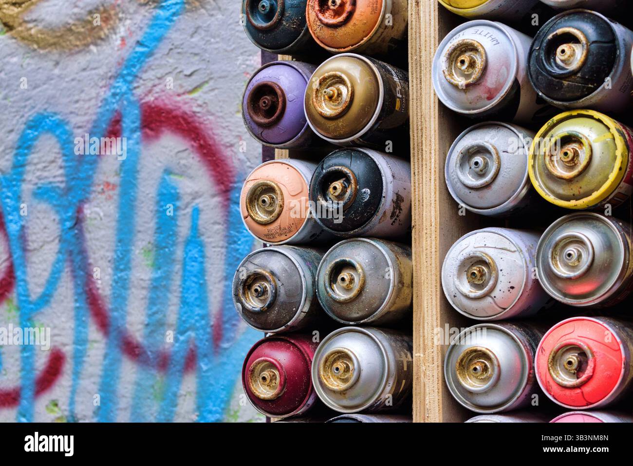 Wall decor with used old spray paint cans. Background with multicolored ...