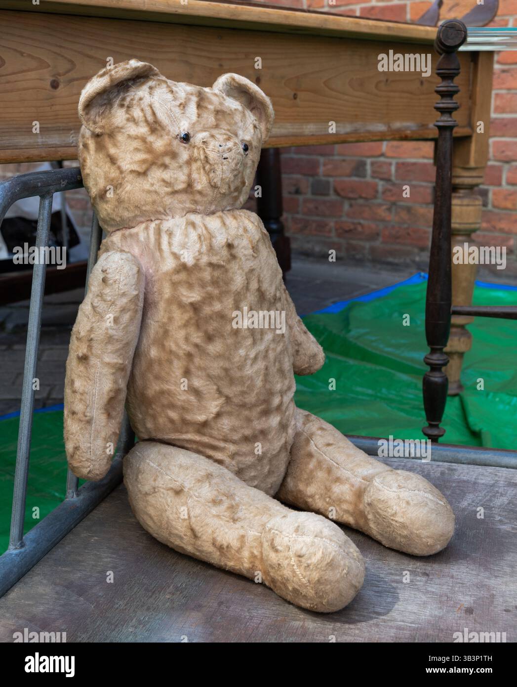 This image features a vintage teddy bear displaying a worn and textured ...
