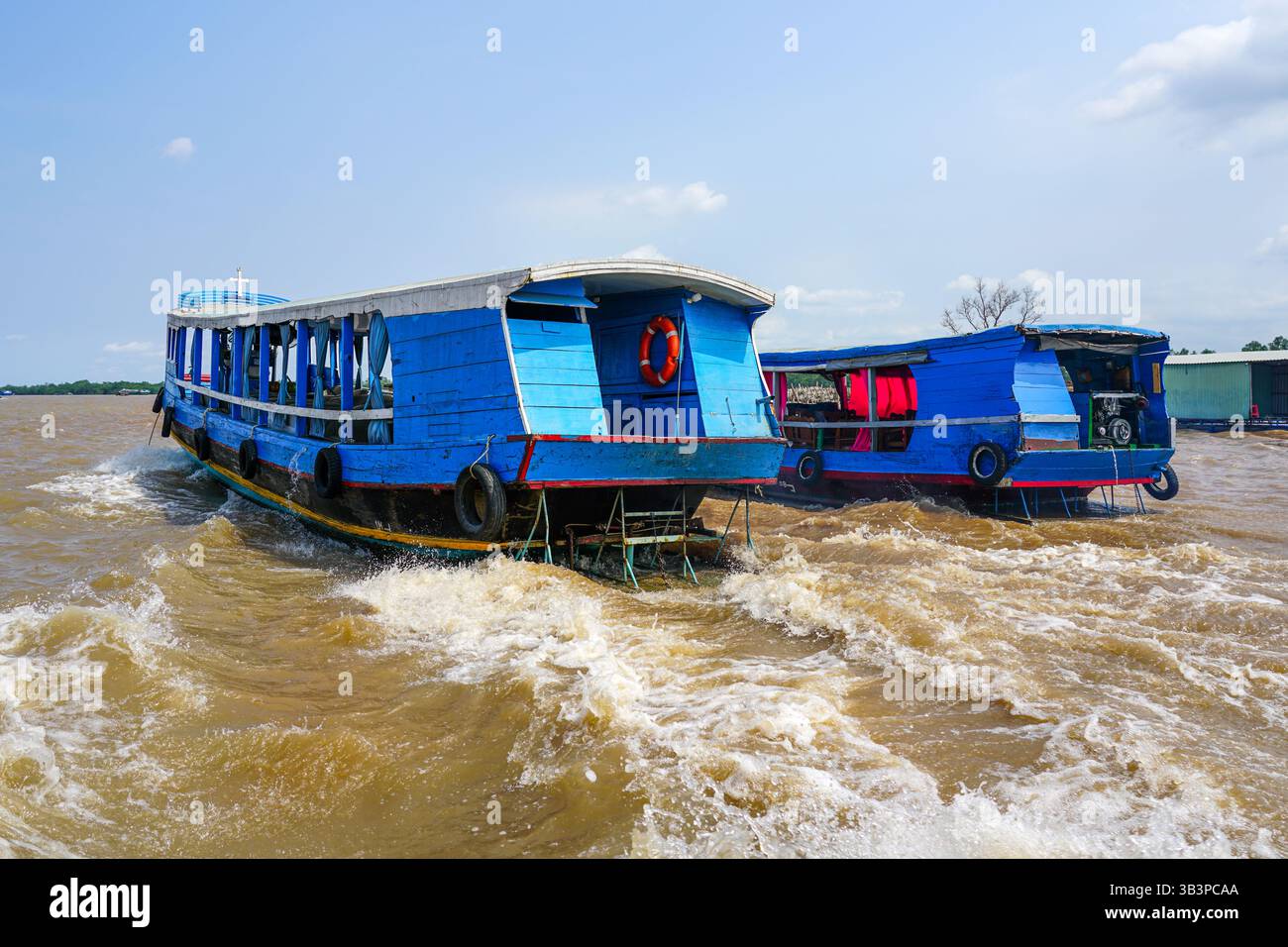 Traditional wooden tourist ferries traffic in the Mekong river delta ...