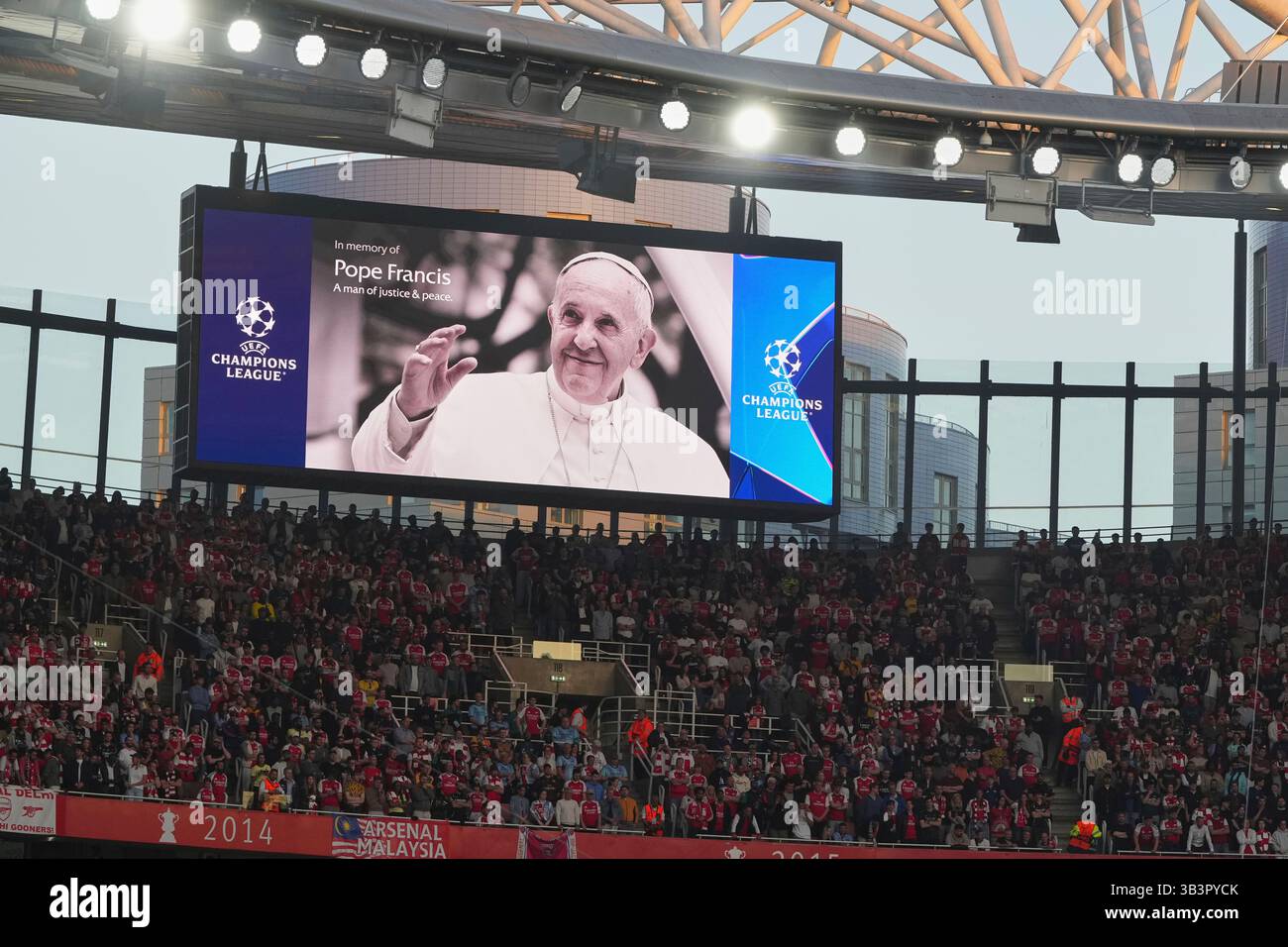 Fans stand for a minute of silence for the late Pope Francis, appearing ...