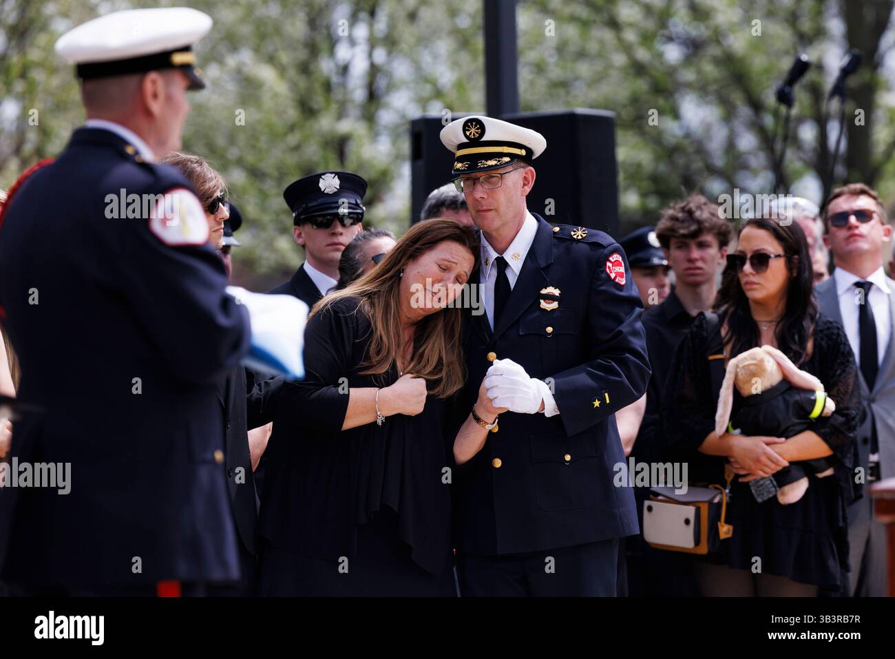 Kristen Meyer, wife, holds onto Battalion Chief Scott Shawaluk during ...