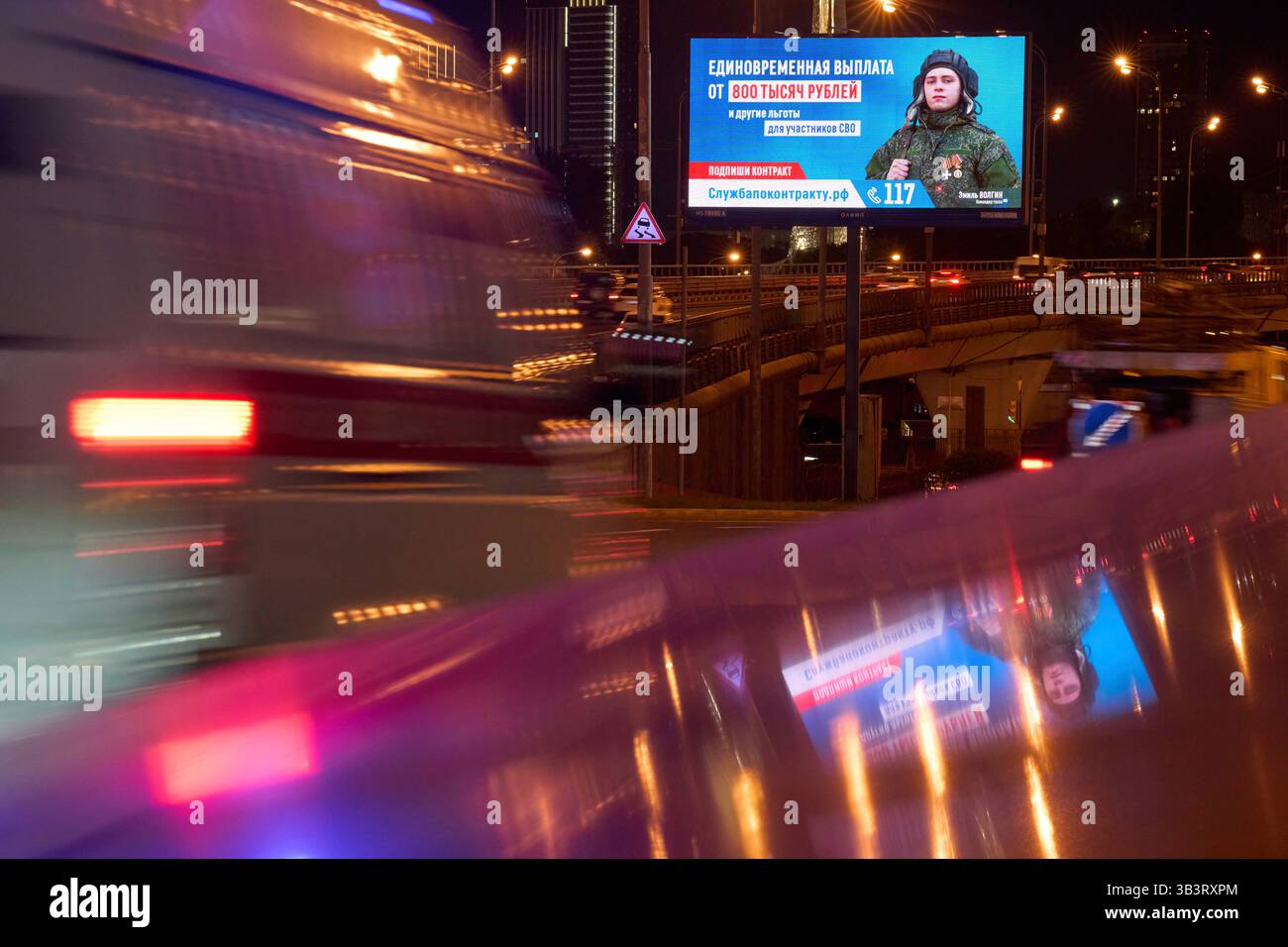 Cars pass an electronic billboard with an advertising screen calling ...