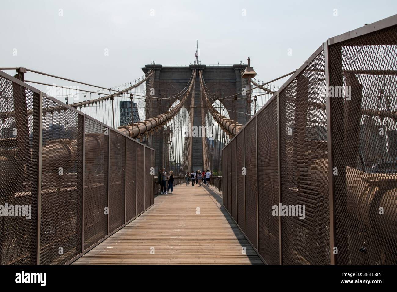 Urban scene of people walking over Brooklyn Bridge in New York with ...