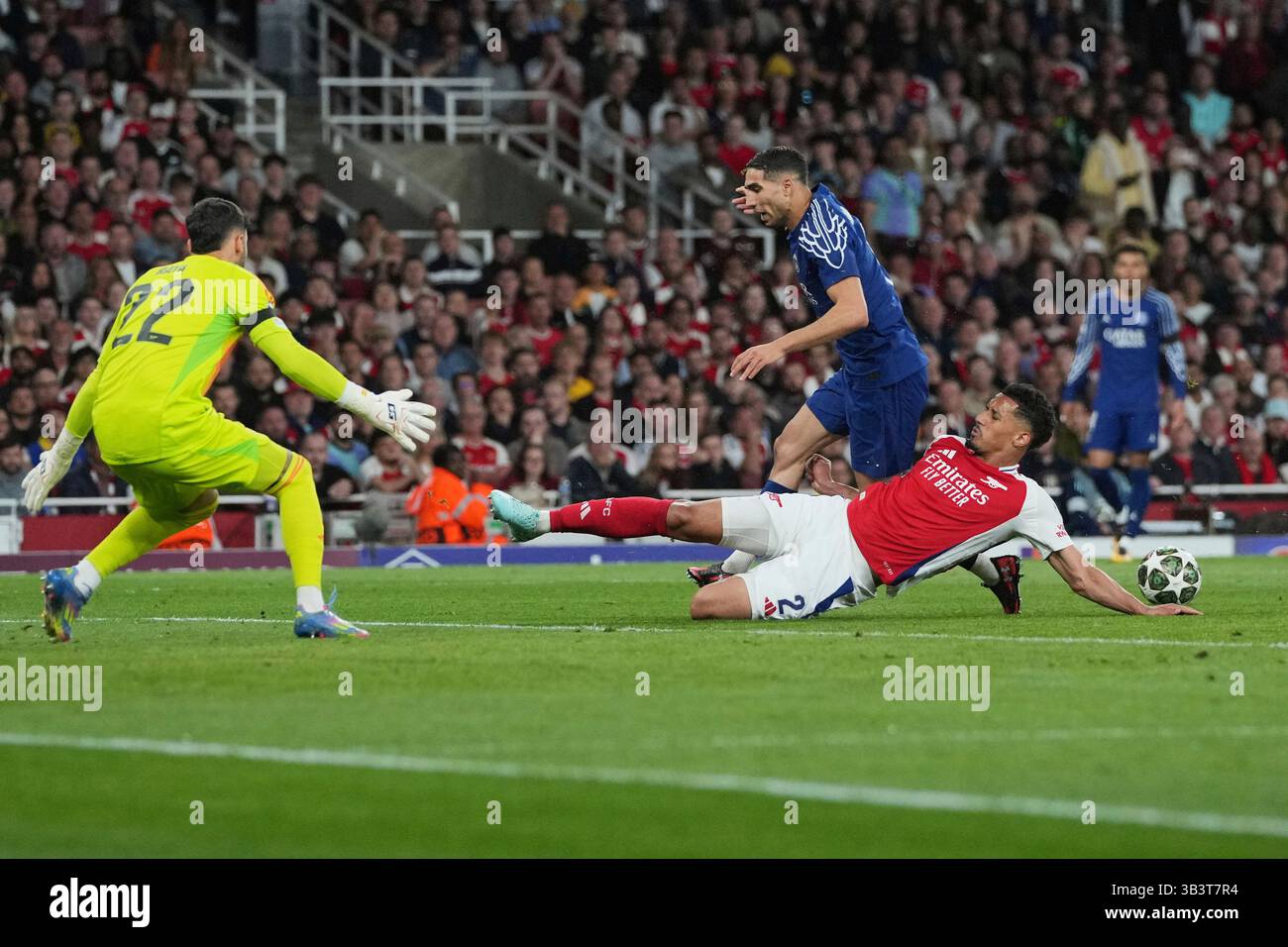 Arsenal's William Saliba slides to tackle PSG's Achraf Hakimi during ...