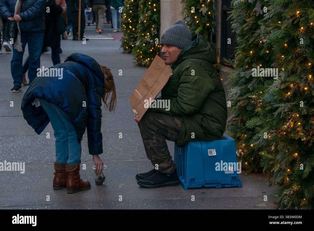 A girl giving alms to a man on the Fifth Avenue, charity, helping the ...