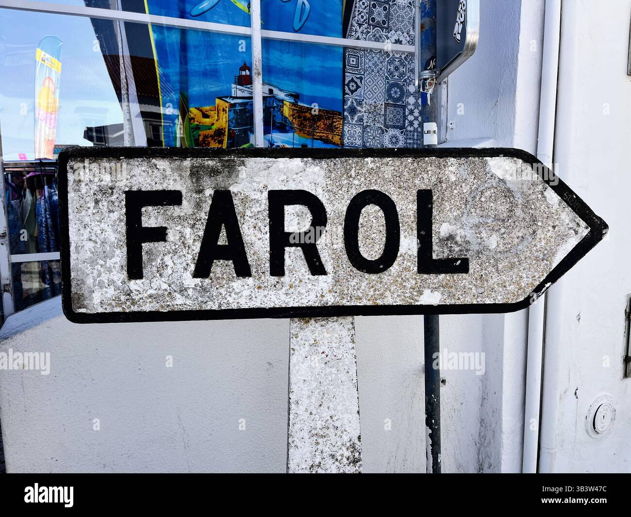 A weathered directional sign indicating the way to Farol in Nazare ...