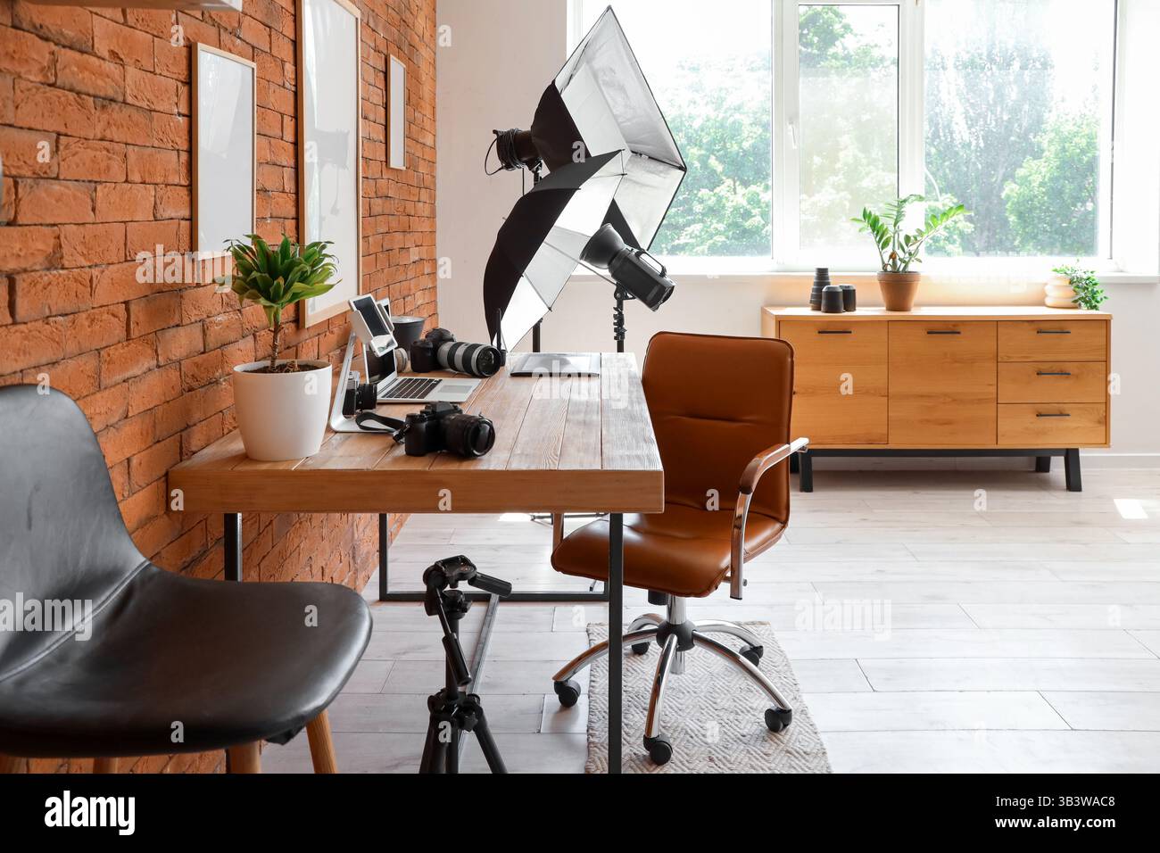 Photographer workplace with laptop, photo cameras and lighting ...