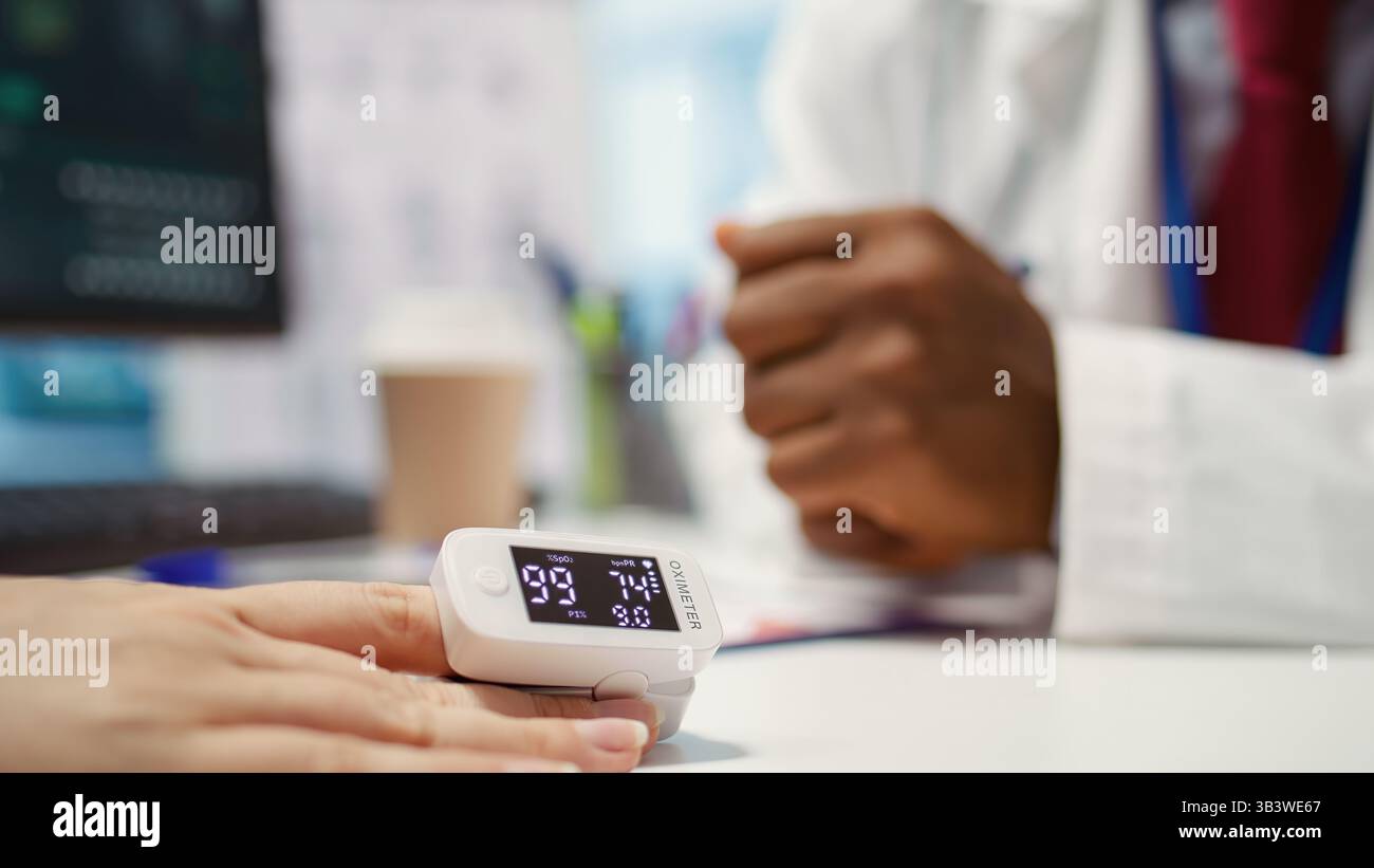 Physician using an oximeter on patient to measure oxygen levels and ...