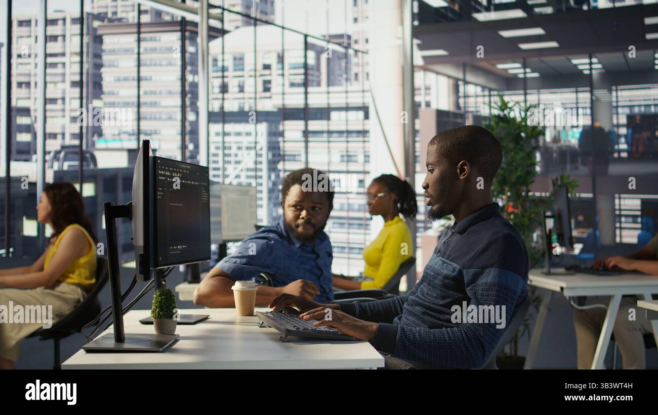 Happy coworker in wheelchair bumping fists with programmer testing ...