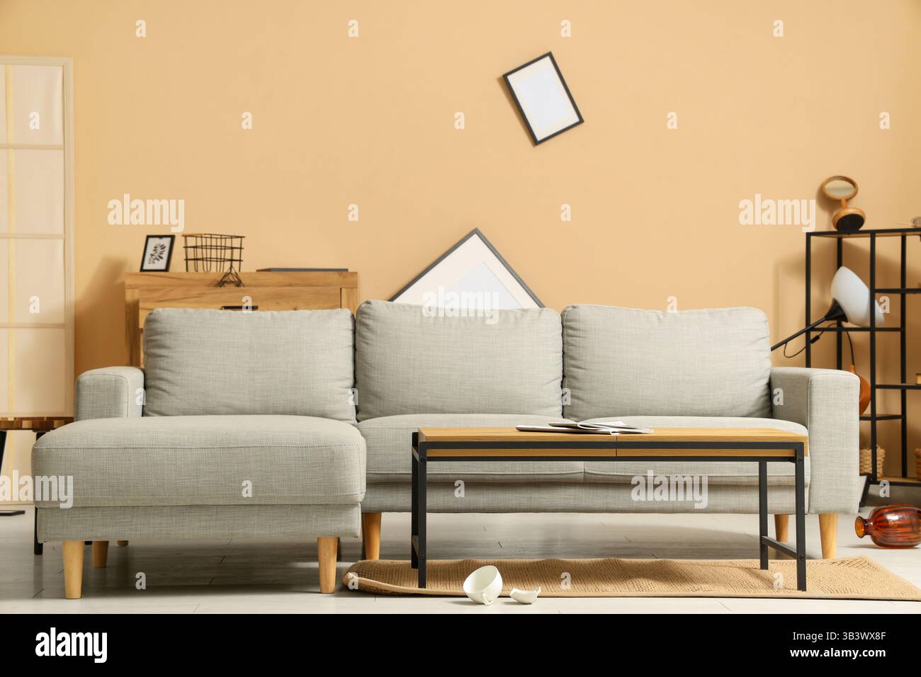 Interior of messy living room with grey sofa, coffee table and ...